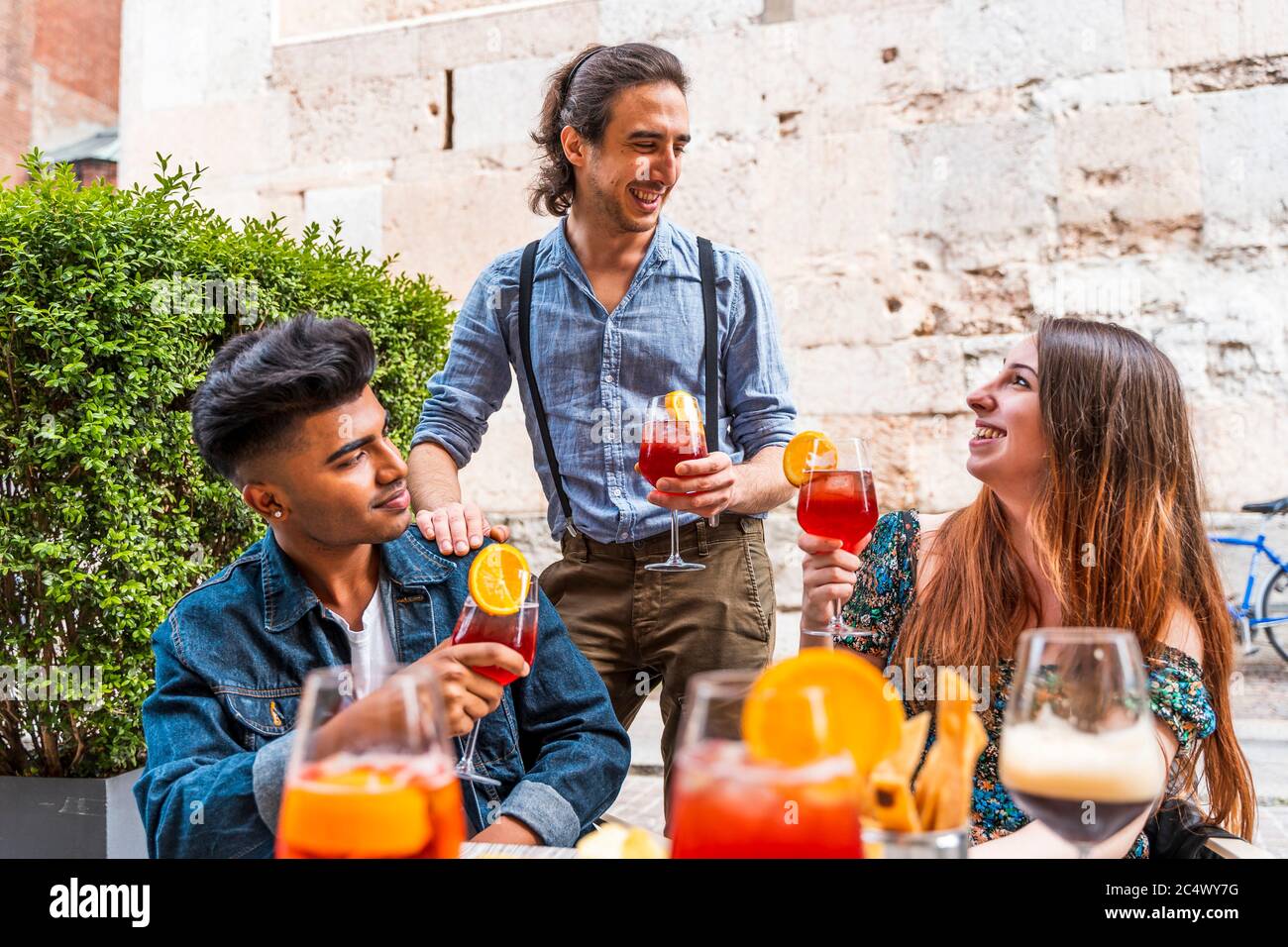 Friends drinking colored cocktail at outdoor bar - New normal ...