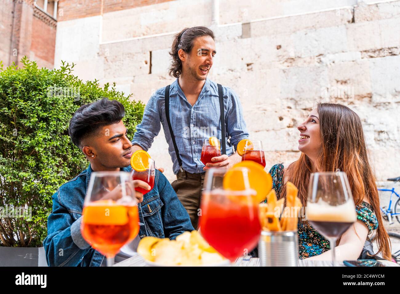 Friends drinking colored cocktail at outdoor bar - New normal ...