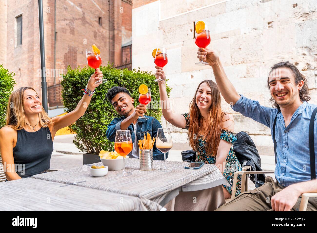 Friends drinking colored cocktail at outdoor bar - New normal ...