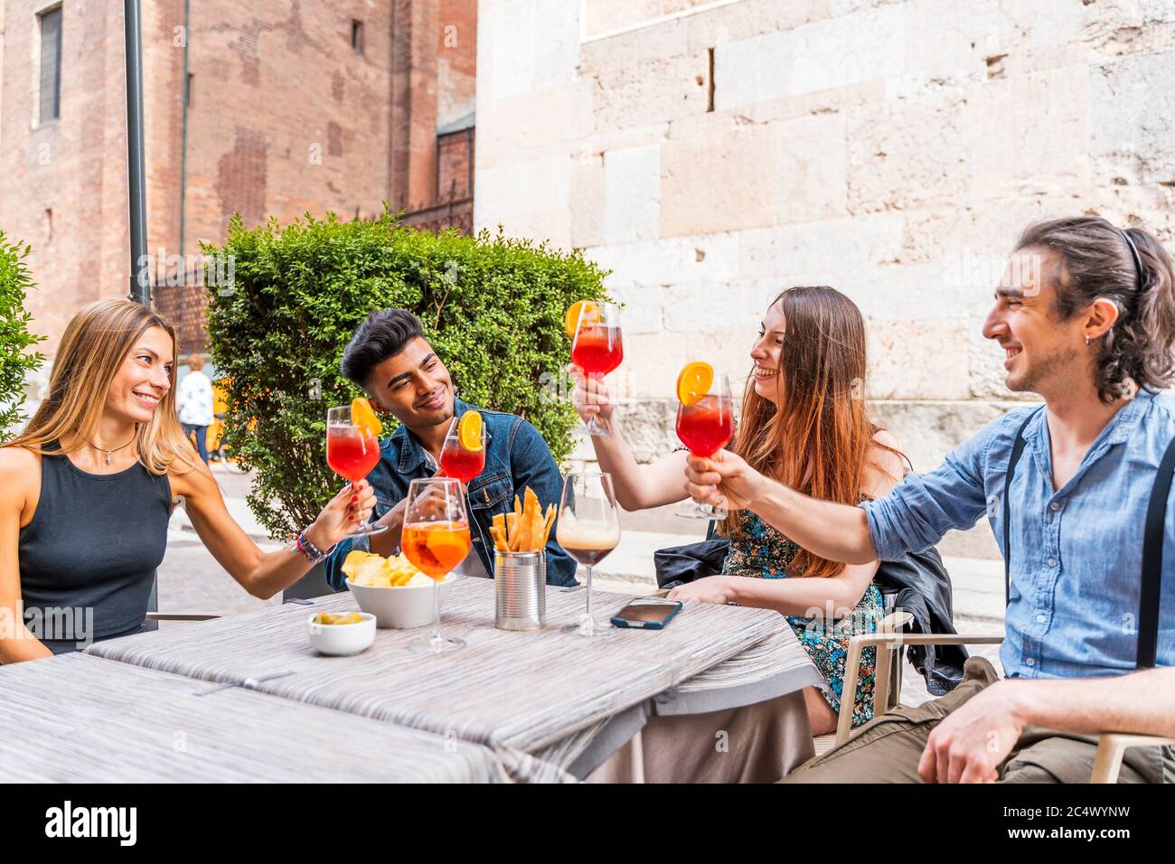 Friends drinking colored cocktail at outdoor bar - New normal ...