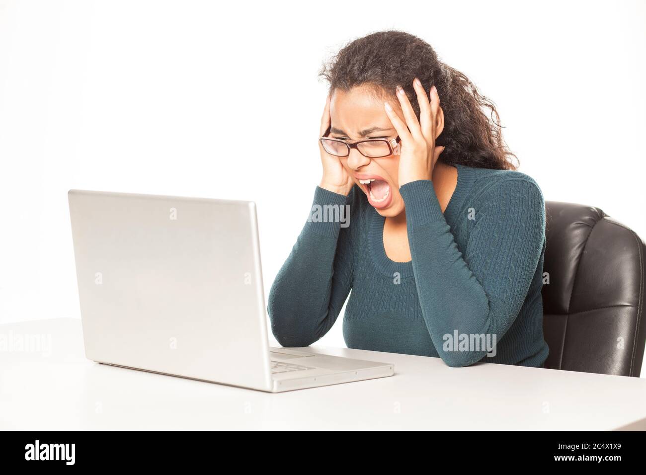 Frustrated young african woman at her laptop on white background Stock ...