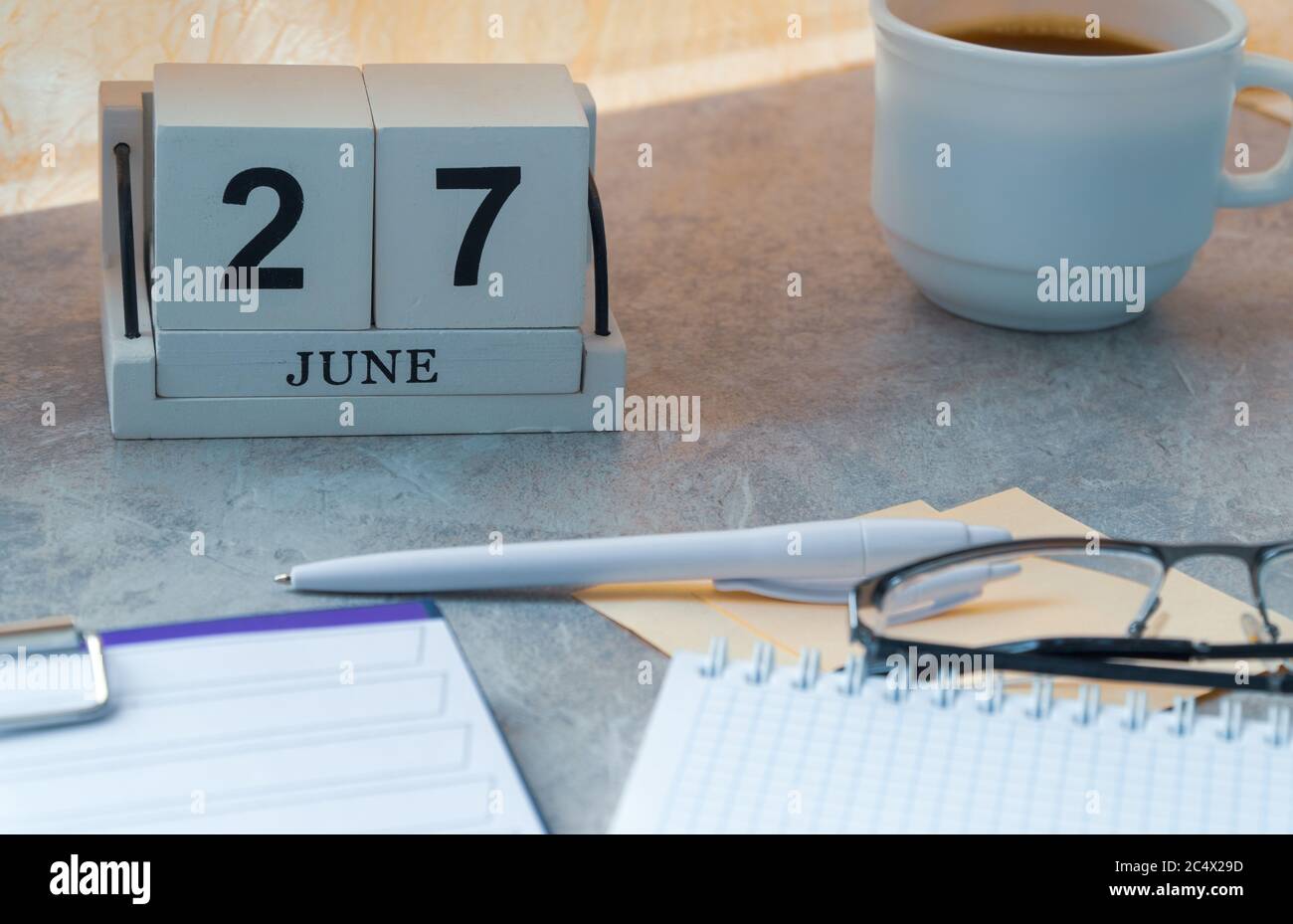 June 27, date on the calendar. Handmade wood cube with date month and ...