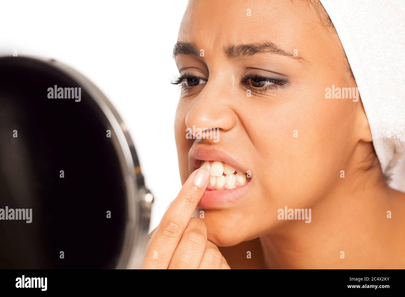 portrait of young dark-skinned woman picking her teeth with finger on ...