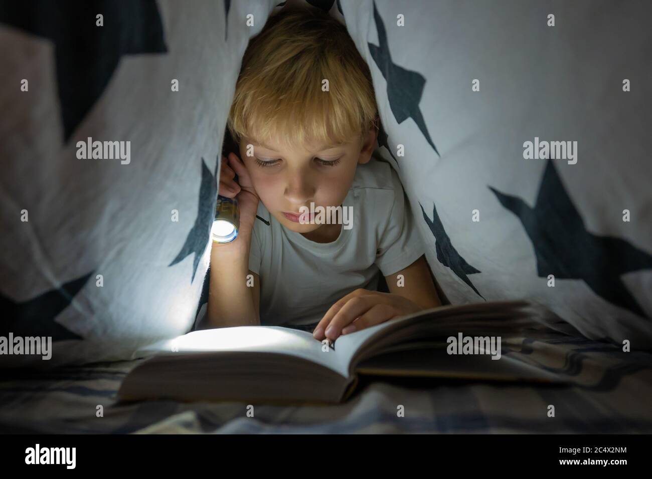 Child read under covers hi-res stock photography and images - Alamy