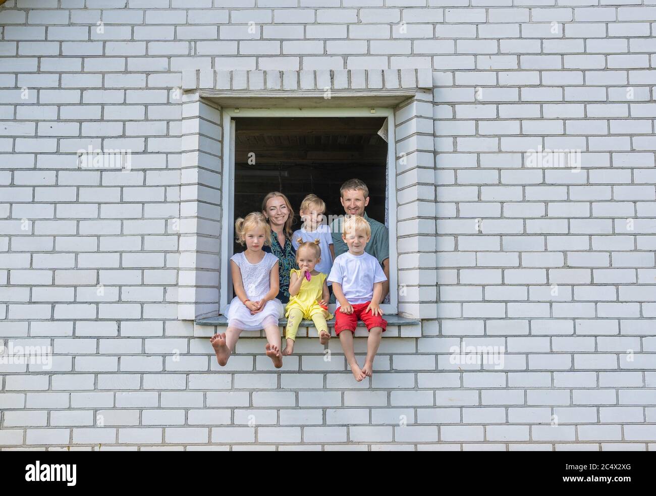 A large large family poses from the window of their home Stock Photo ...