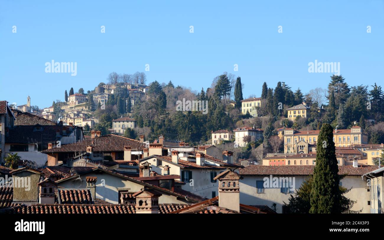 Roofs and chimneys in the residential area of Bergamo Alta with hills ...