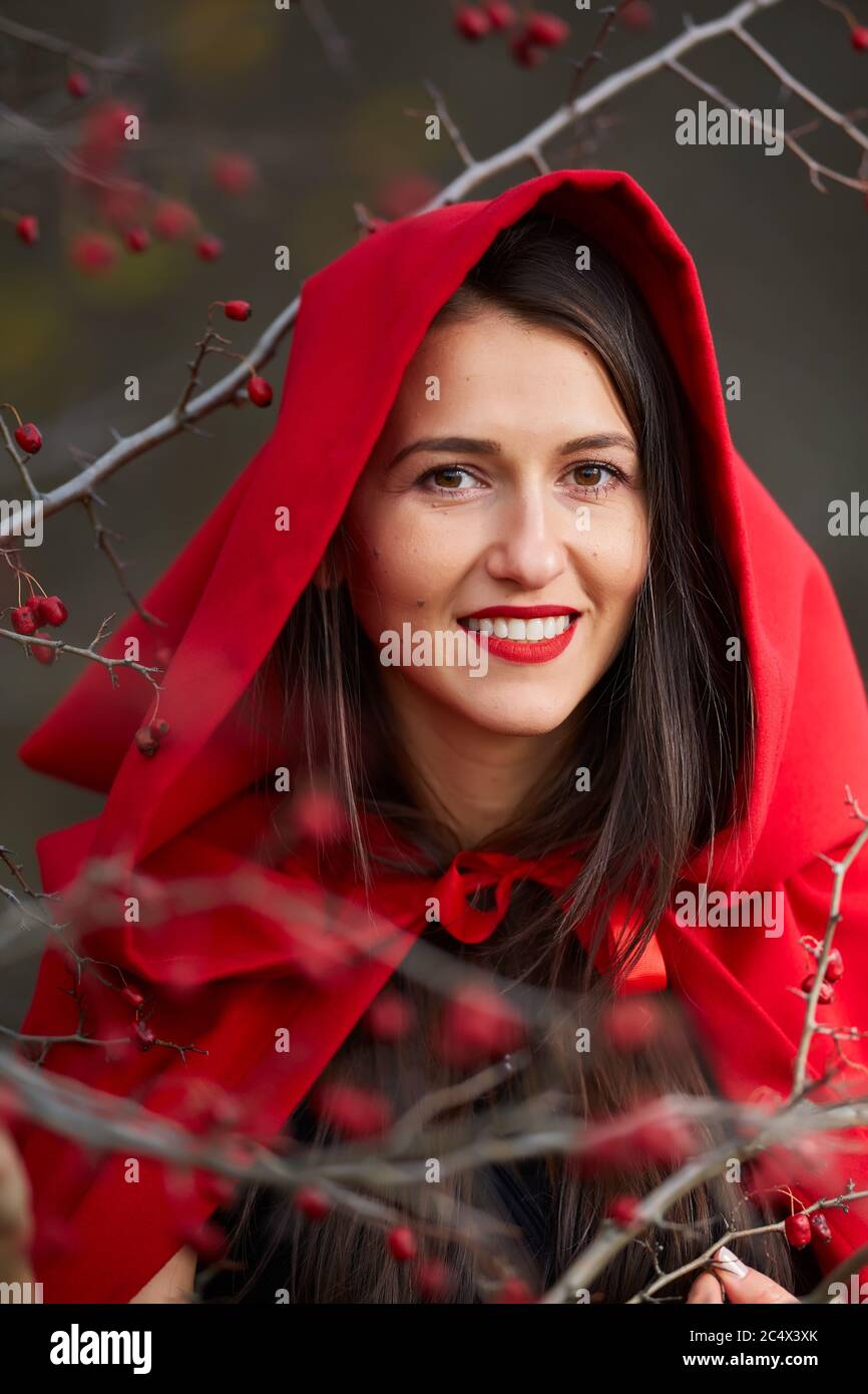 Woman dressed as Red Riding Hood in various postures in the forest ...