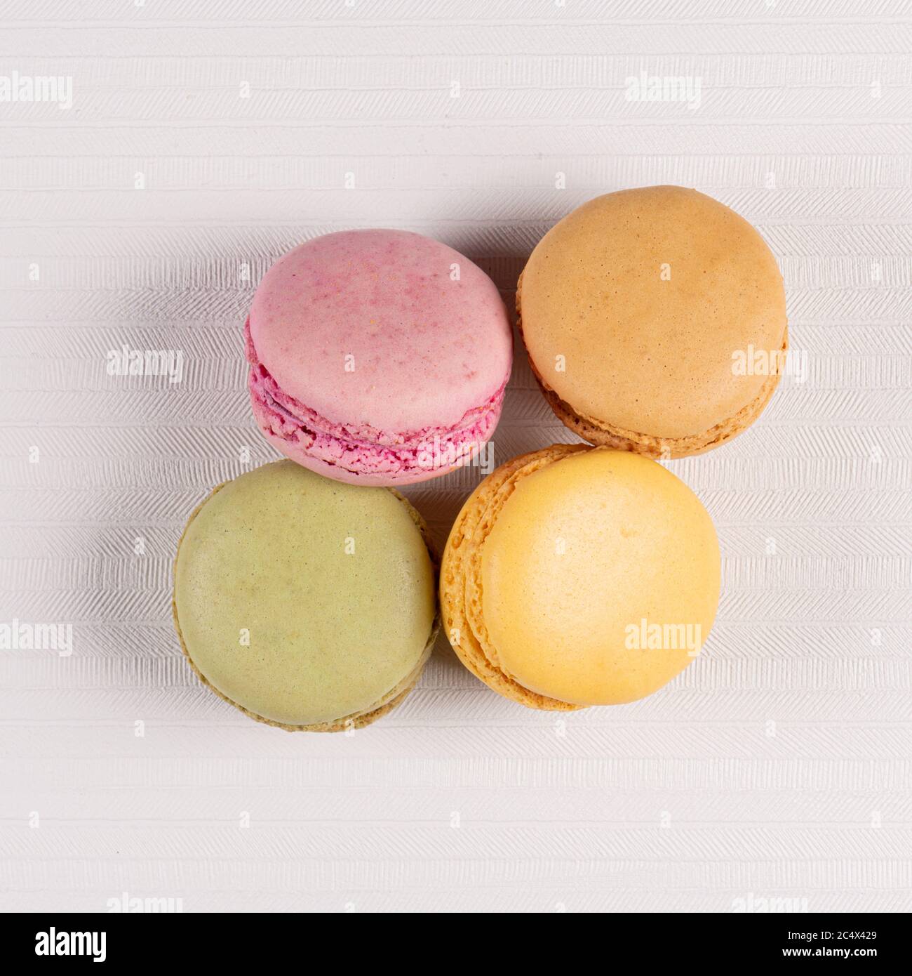 Four macaroonson white vinyl background Stock Photo - Alamy