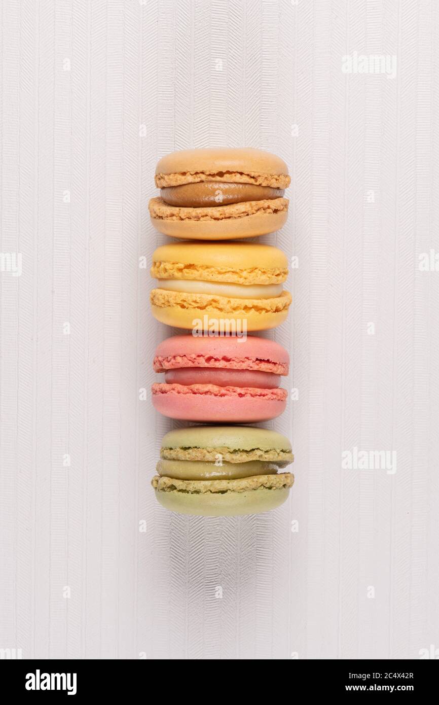 Four macaroonson white vinyl background Stock Photo - Alamy