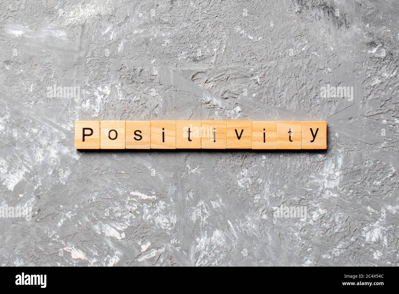 positivity word written on wood block. positivity text on cement table for your desing, concept ...
