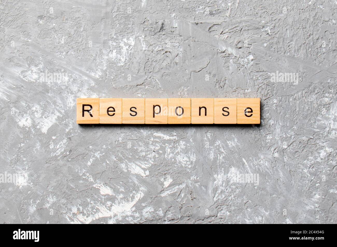RESPONSE word written on wood block. RESPONSE text on cement table for ...