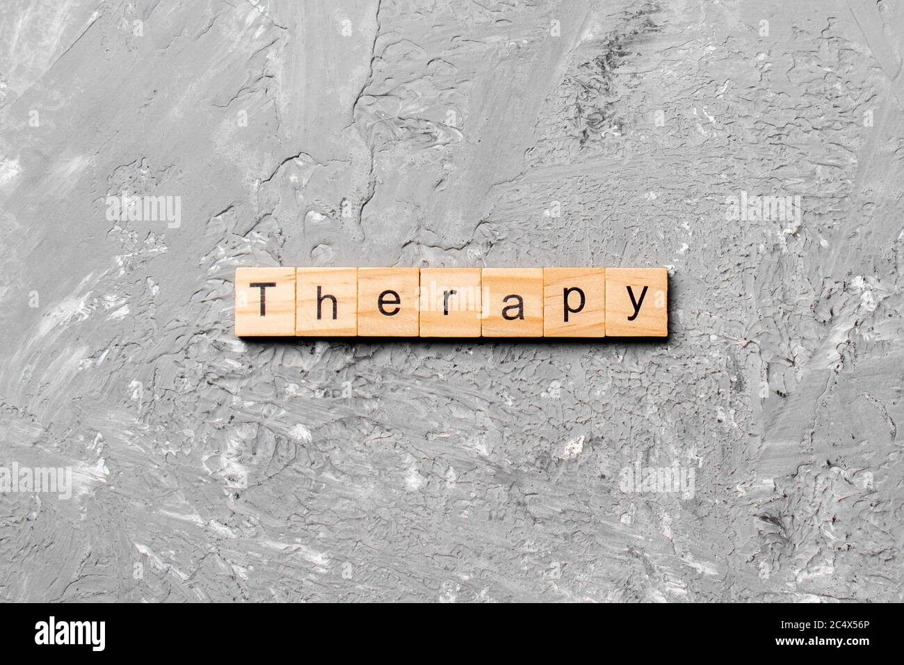 therapy word written on wood block. therapy text on cement table for ...