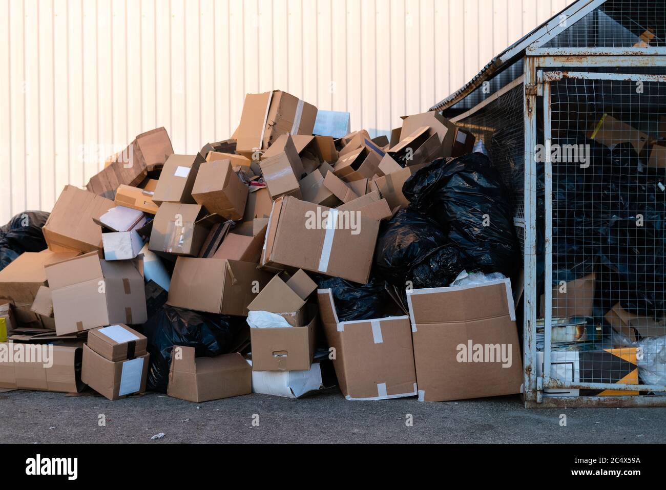 Paper boxes next to a garbage bin. Stack of paper waste outdoor in the ...