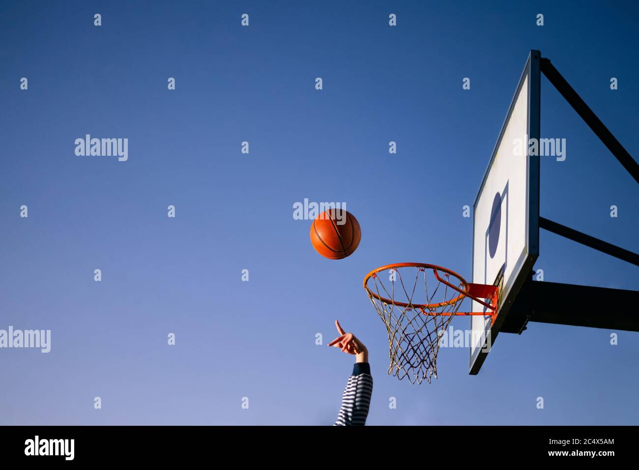 Street basketball ball player throwing ball into the hoop. Close up of ...