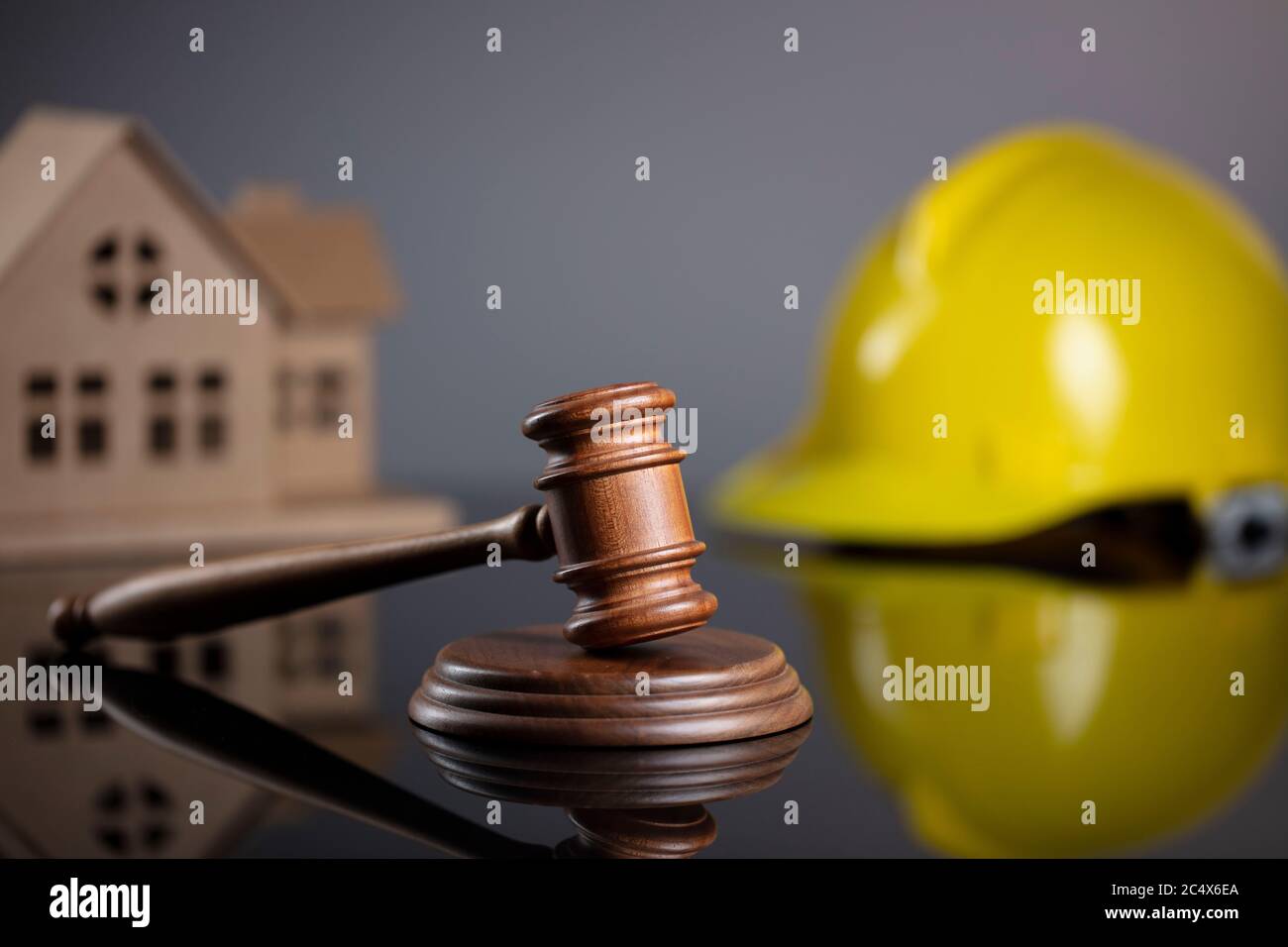 Law theme. Construction law's symbols - yellow helmet, house model and ...