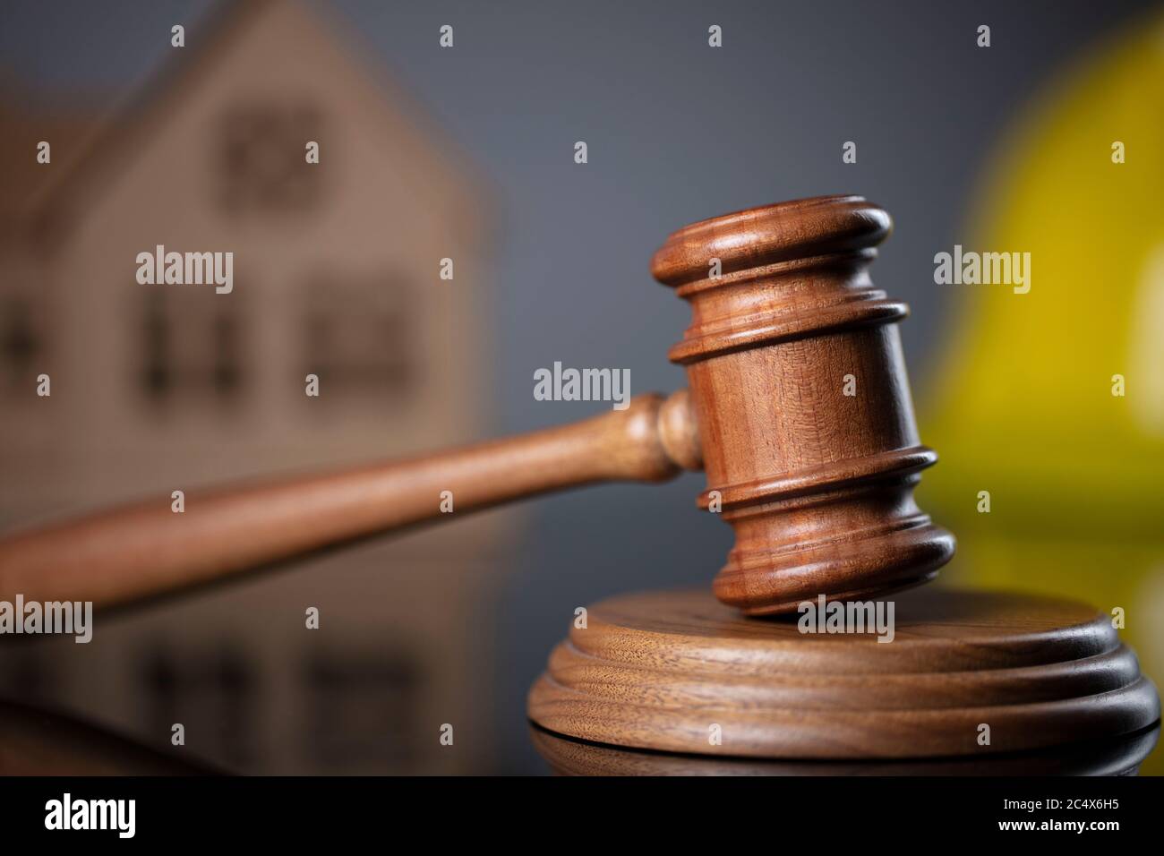 Law theme. Construction law's symbols - yellow helmet, house model and ...