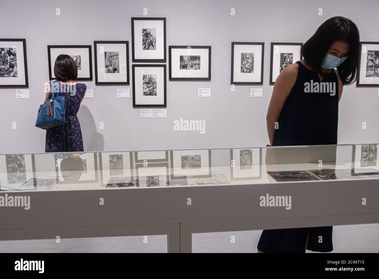 A woman looks on while wearing a face mask as a preventive measure ...