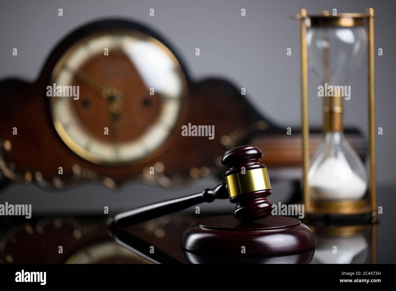 Law concept. Judge wooden gavel, scale, old clock and Themis statue on ...