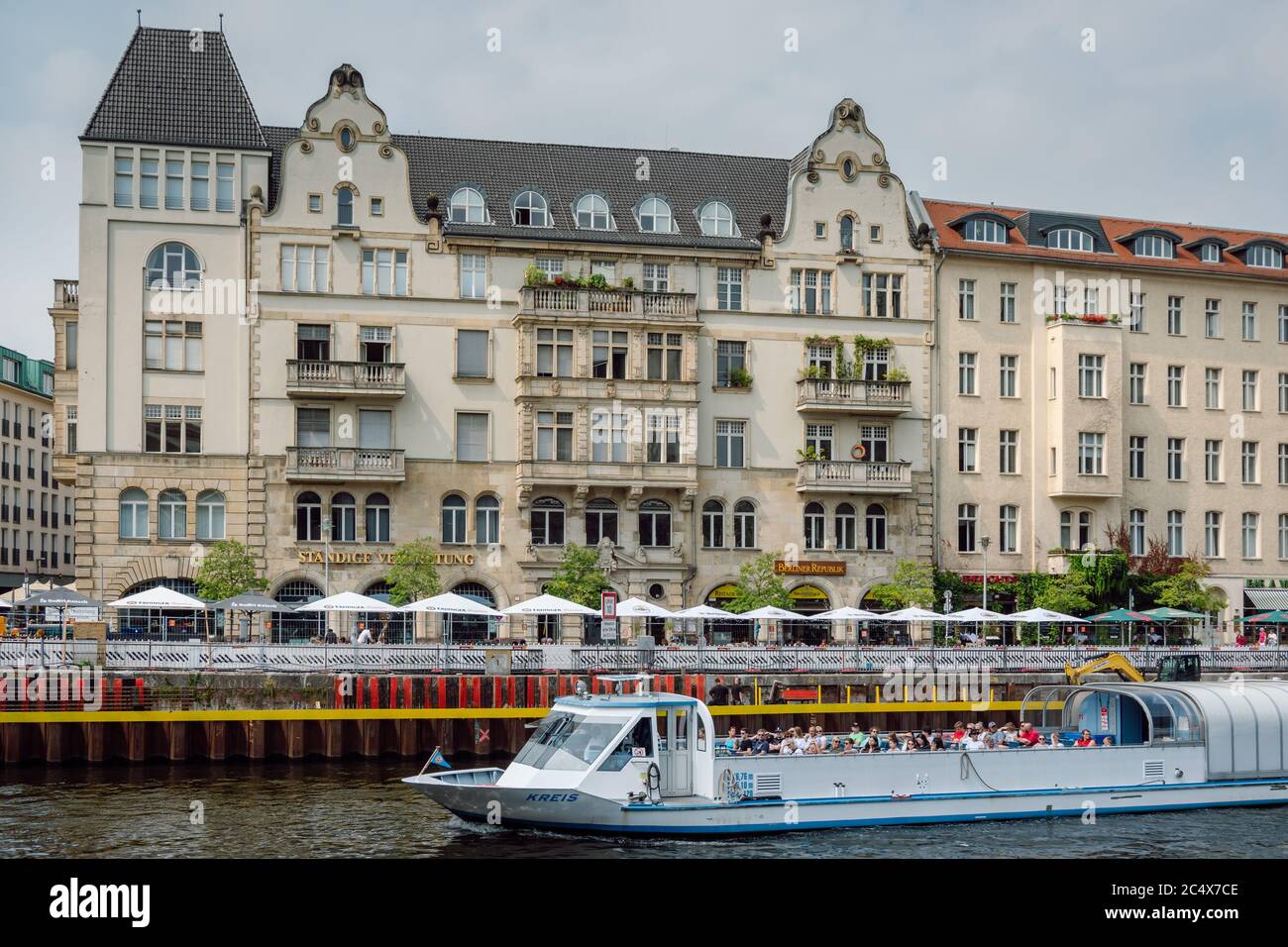 Elegant riverside buildings with outdoor restaurants and bars on ...