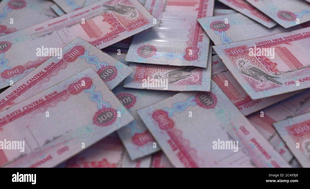 A close-up view of a scattered pile of UAE dirham banknotes - 3D render ...