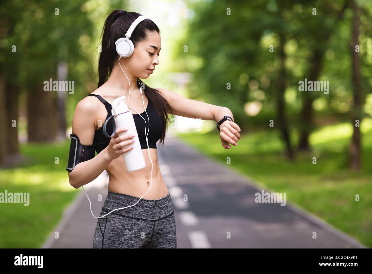 Fitness Tracker Concept. Sporty Asian Girl Looking At Smartwatch On Her ...