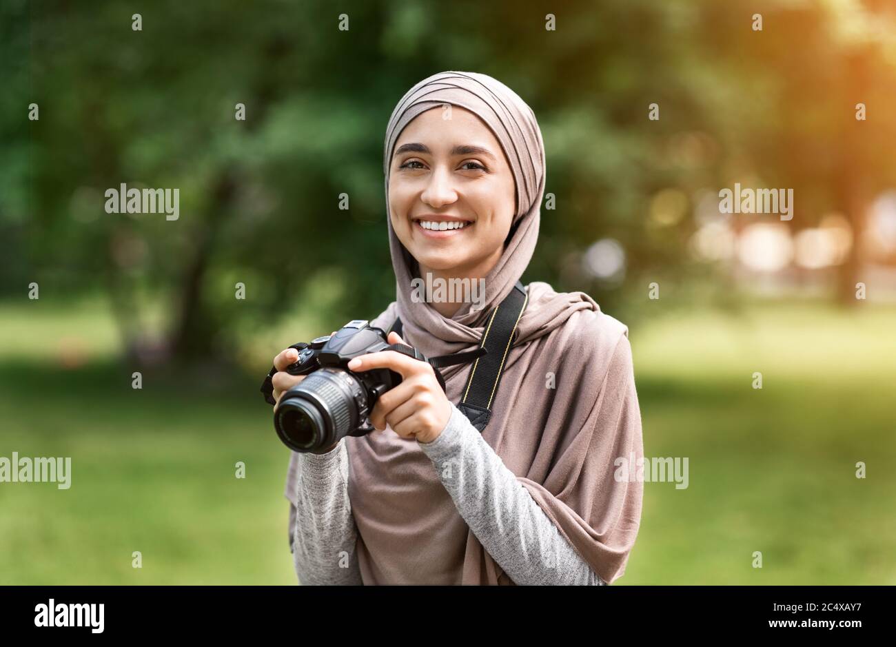 Portrait of beautiful muslim woman photographer with digital camera ...