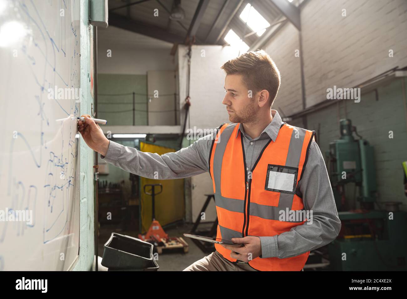 Male factory worker writing on a whiteboard at the factory Stock Photo ...