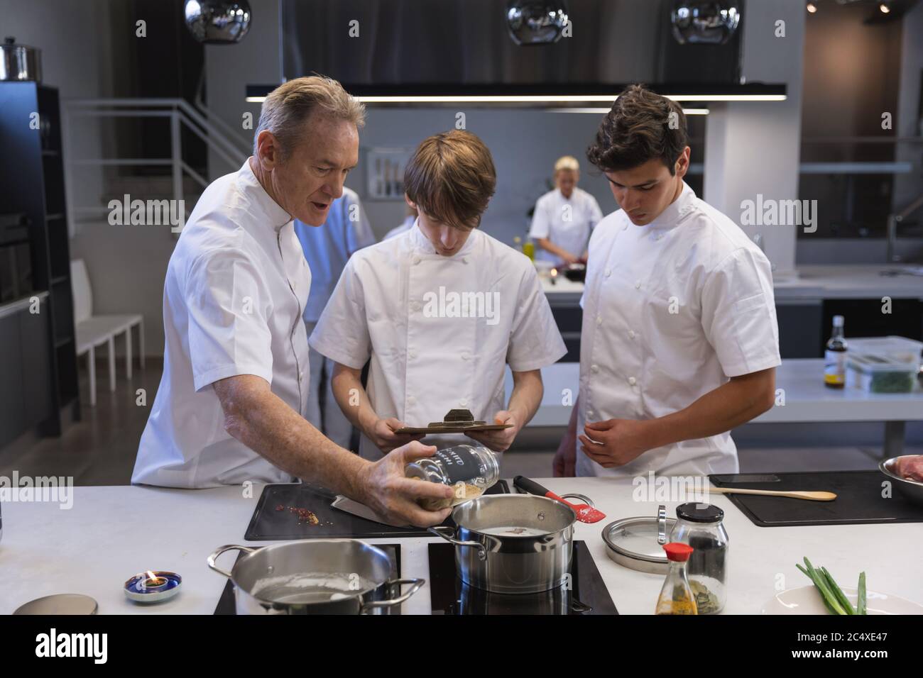 Group of chefs working at restaurant kitchen Stock Photo - Alamy