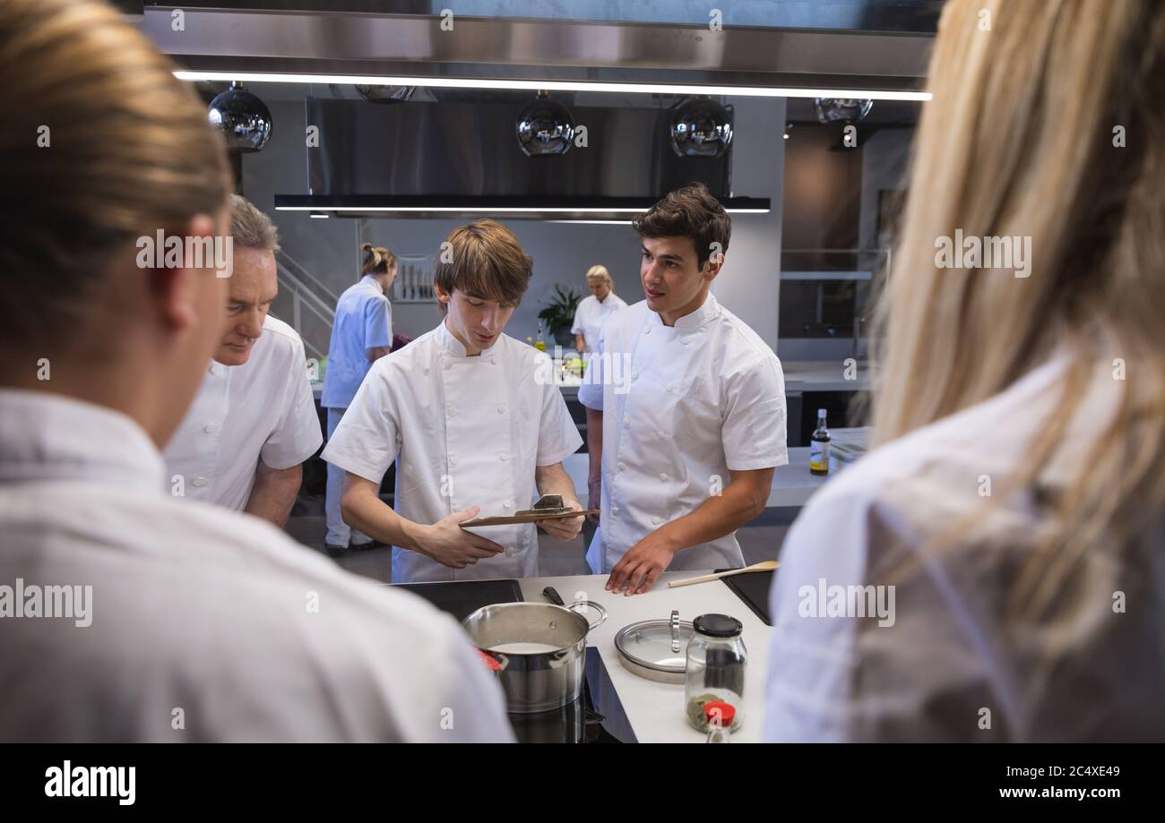 Group of chefs working at restaurant kitchen Stock Photo - Alamy
