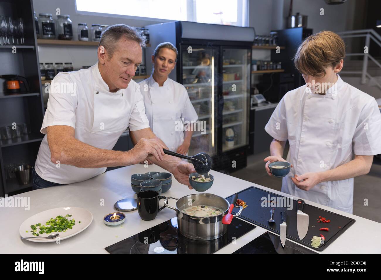 Senior male chef teaching cooking to young male chef at restaurant ...