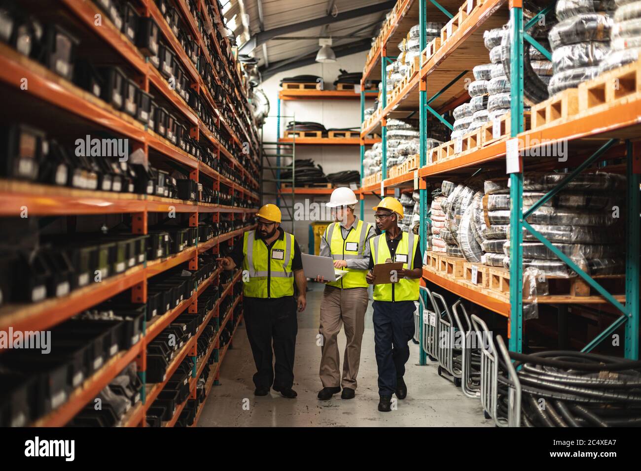 Three male factory workers checking stock at the factory Stock Photo ...