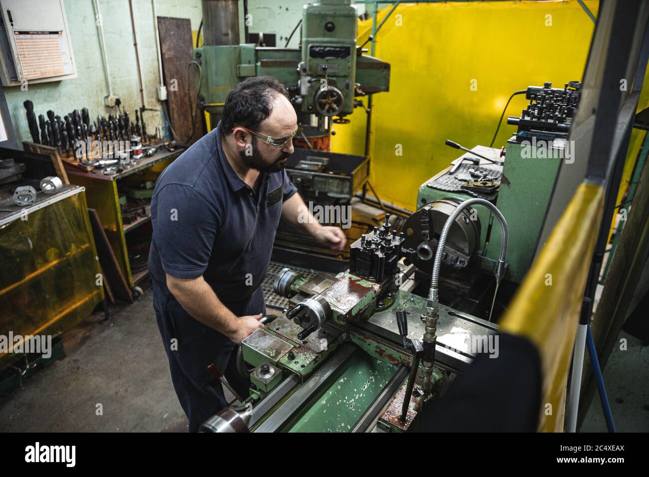 Male factory worker operating machinery at the factory Stock Photo - Alamy