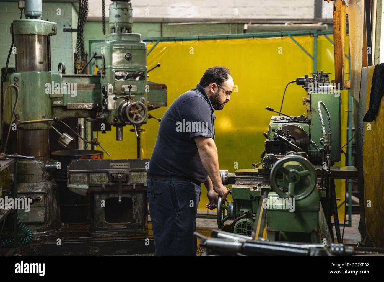 Male factory worker operating machinery at the factory Stock Photo - Alamy
