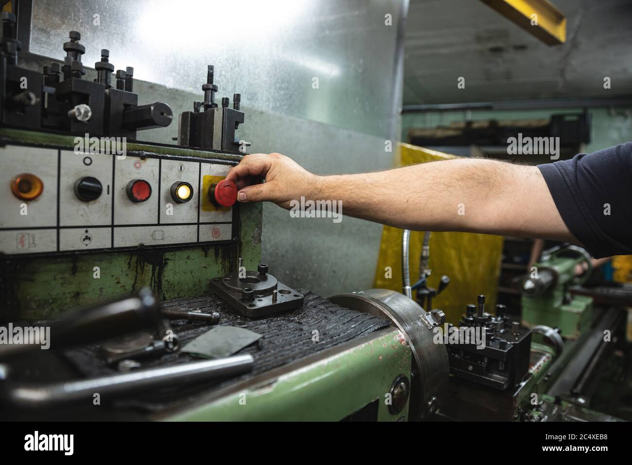 Mid-section of a male factory worker pressing machine button at the ...