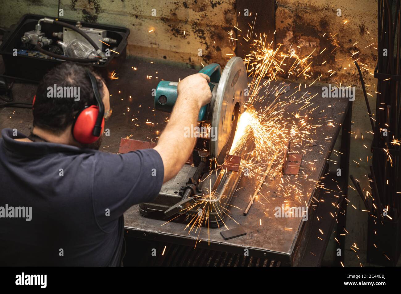 Male factory worker cutting metal using machinery at the factory Stock ...