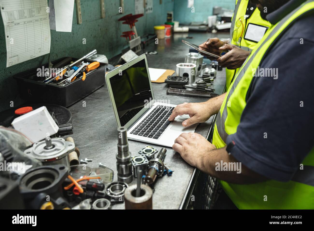 Mid-section of a male factory worker using laptop at the factory Stock ...