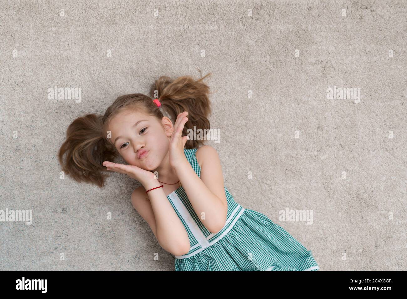 Cute preschool girl making funny faces, playing, having fun while lying ...