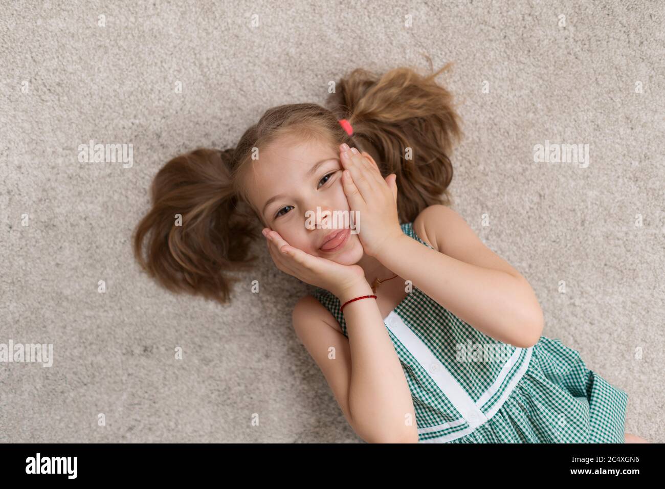 Cute preschool girl making funny faces, playing, having fun while lying ...