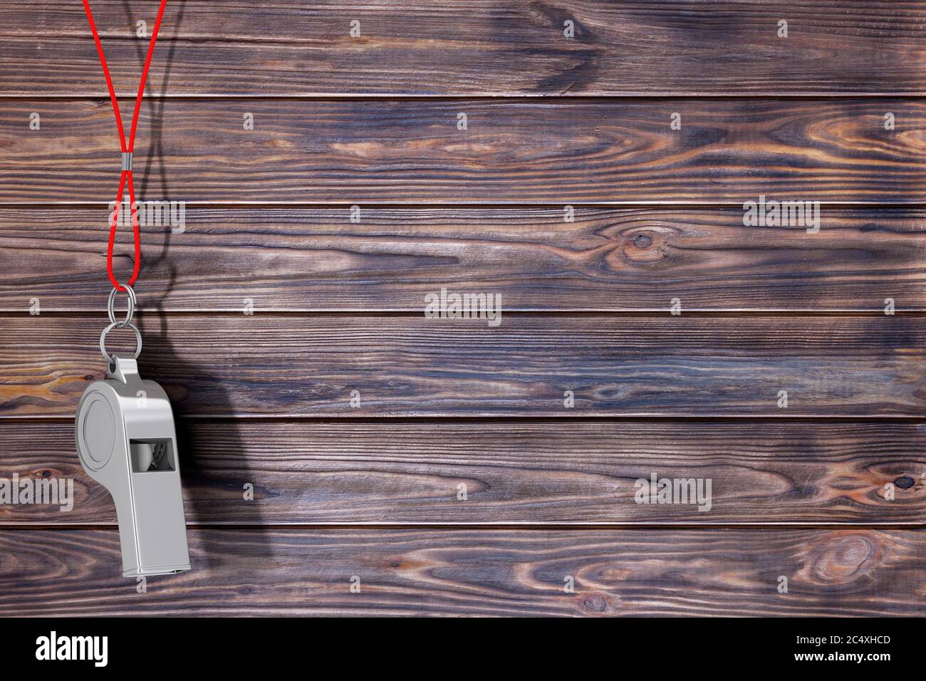 Classic Metal Coaches Whistle Hanging on Red Rope on a wooden planks ...