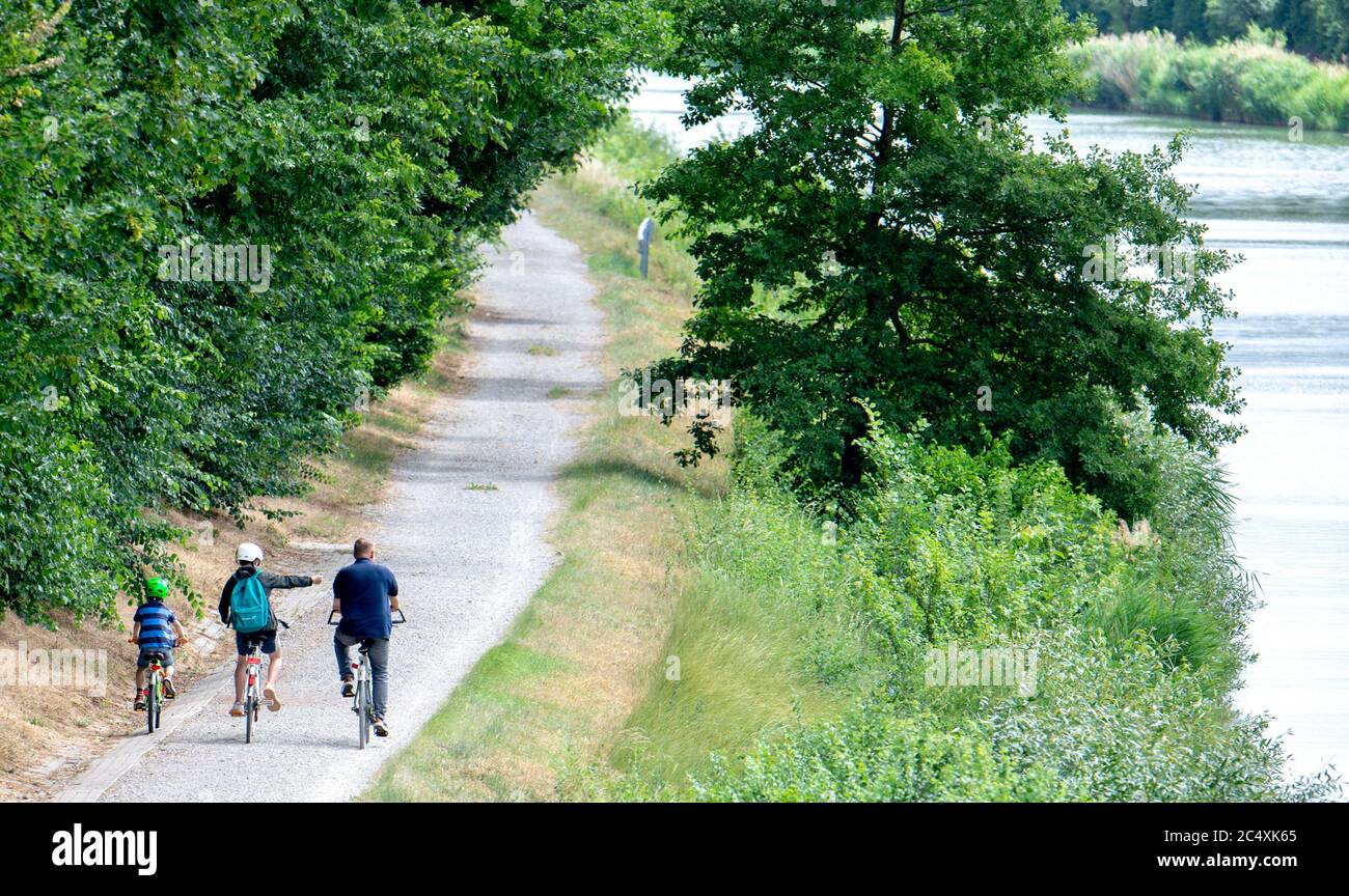 Sehnde, Germany. 29th June, 2020. A father rides his two sons on a ...