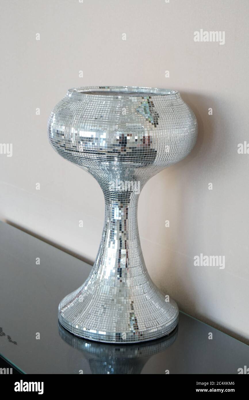 Vase decorated with mosaic of mirror glasses on the table. The glued ...