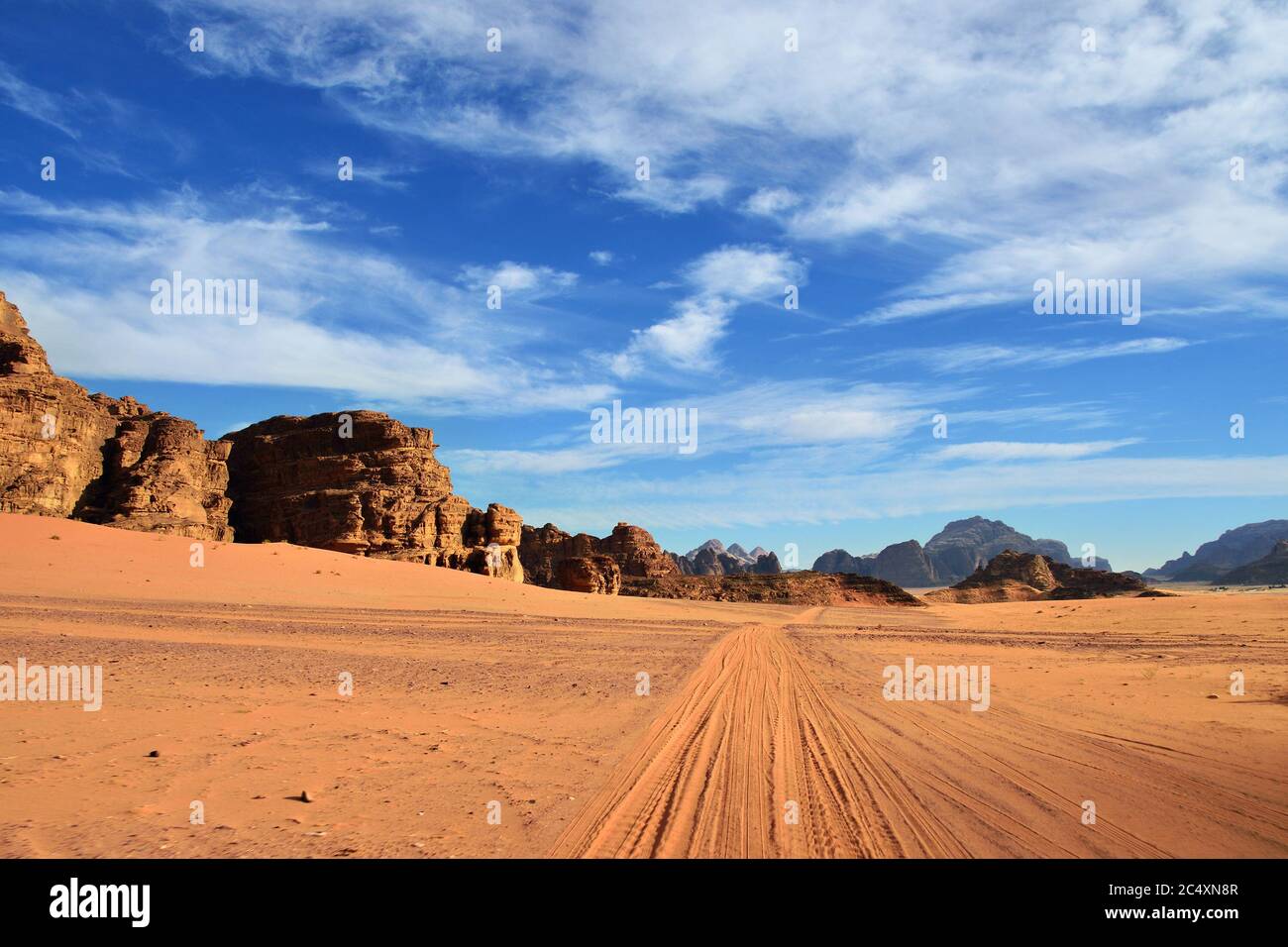 Dirt road in the Wadi Rum (Moon Valley) desert landscape at sunset time ...