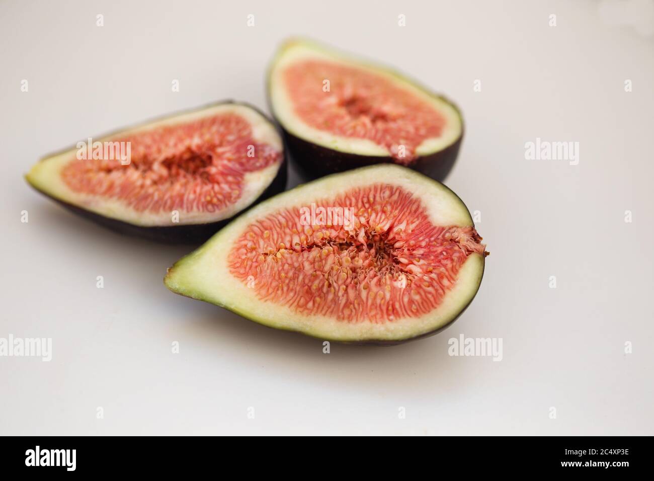 Closeup image of figs cut in half on white background Stock Photo - Alamy