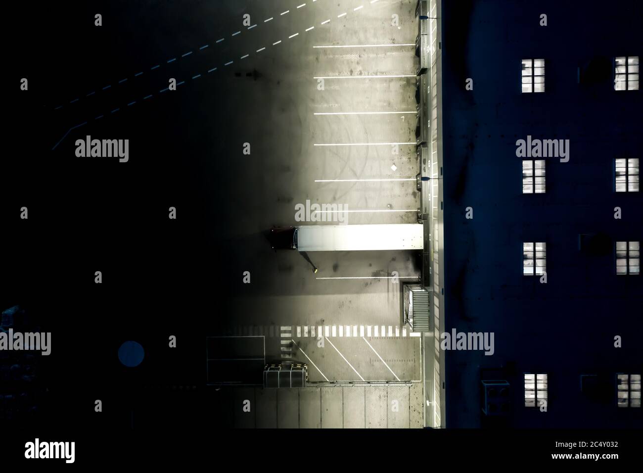 Night Aerial view of trucks unloading in logostics center. Logistics ...