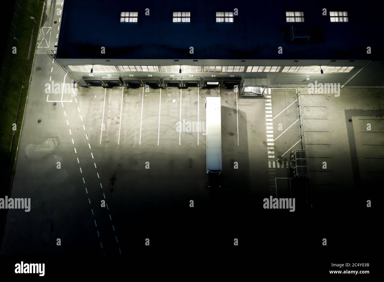 Night Aerial view of trucks unloading in logostics center. Logistics ...