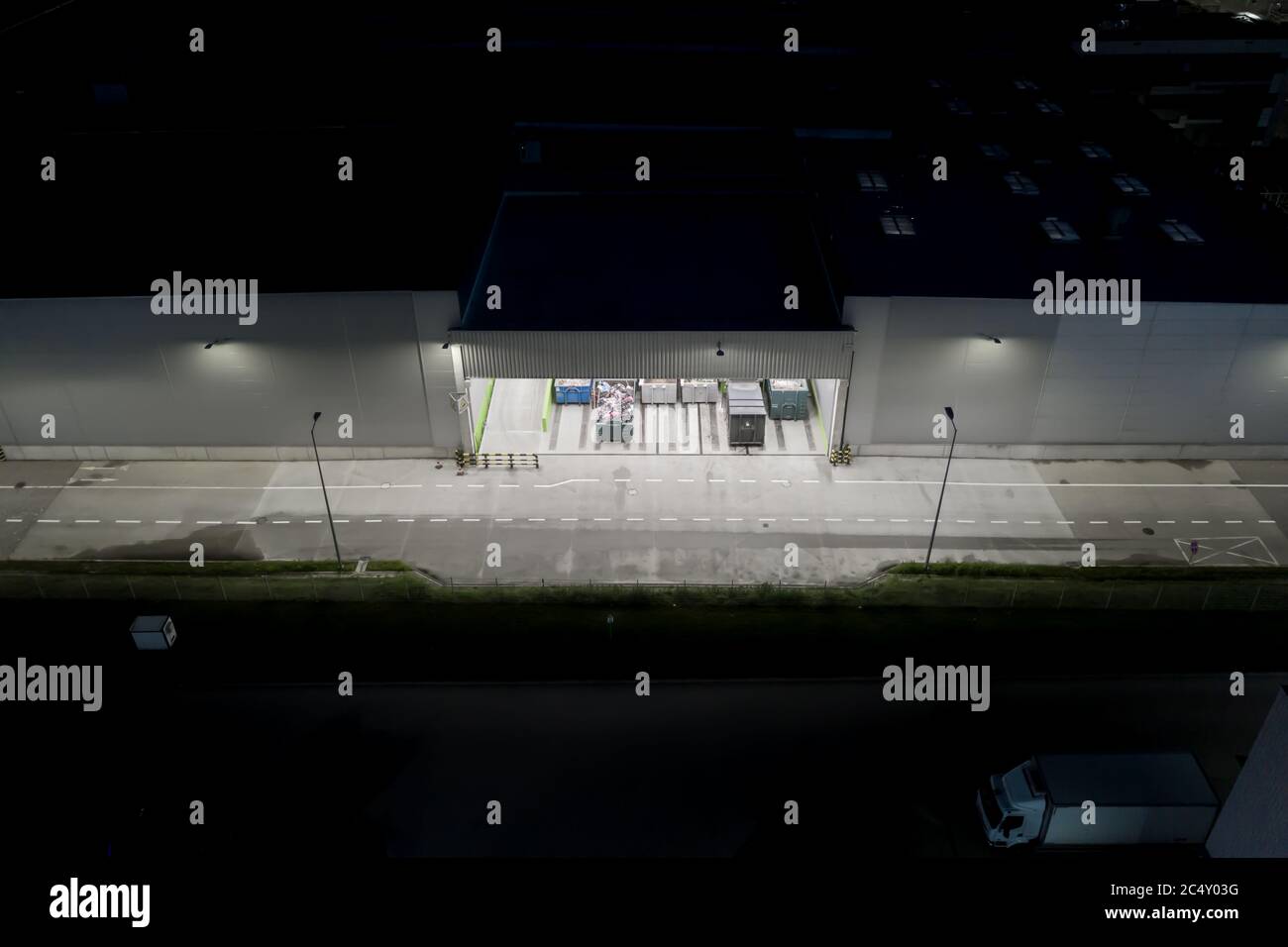 Night Aerial view of trucks unloading in logostics center. Logistics ...