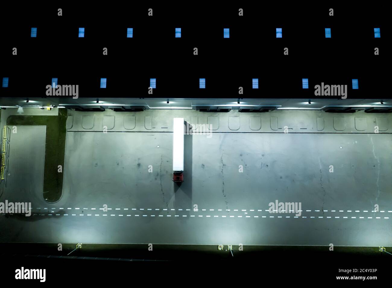 Night Aerial view of trucks unloading in logostics center. Logistics ...