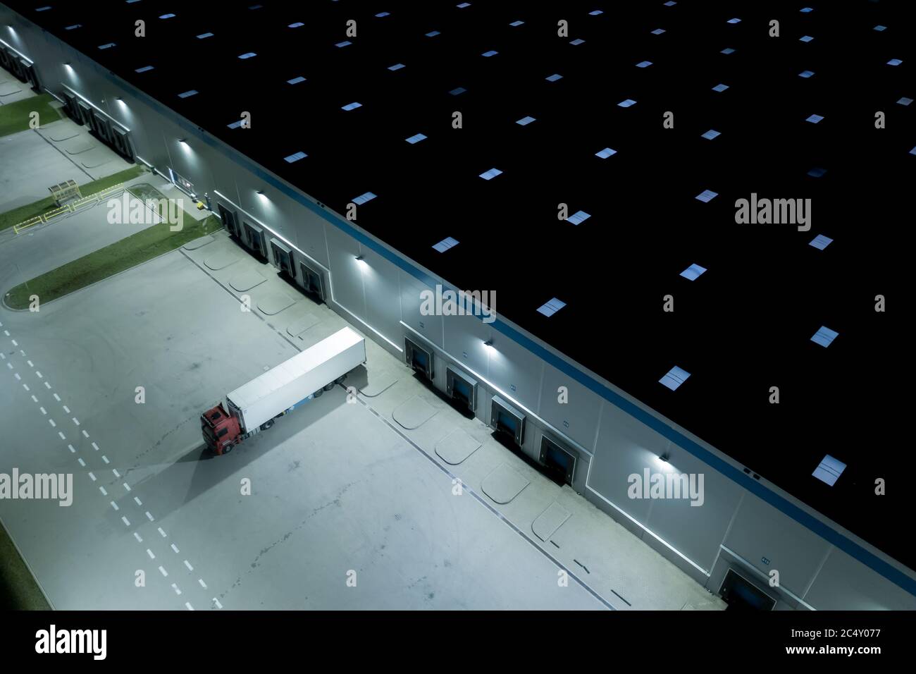 Night Aerial top view of truck and cargo trailer unloading in logostics ...