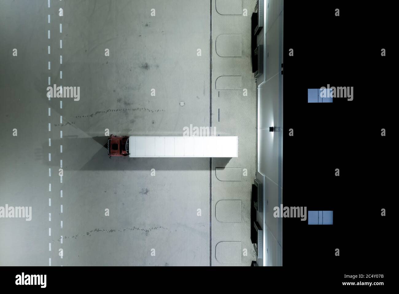 Night Aerial top view of truck and cargo trailer unloading in logostics ...