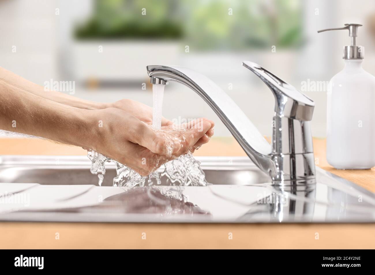 Male hands under tap water in a kitchen Stock Photo - Alamy